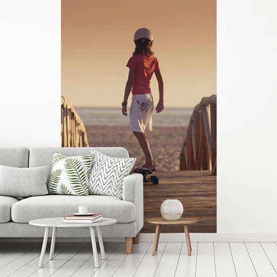 Behang - Fotobehang Een jong persoon rijdt met zijn skateboard over een ...