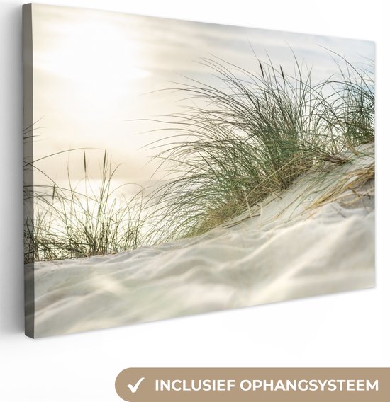 Canvas schilderij 140x90 cm - Wanddecoratie Duinen met helmgras onder de zon van het... | bol