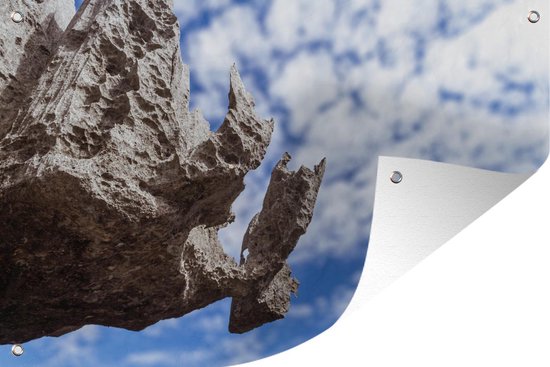 Tuindecoratie Schapenwolkjes in de lucht achter een hangende rots in ...