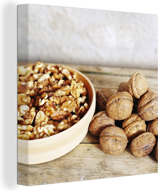 Canvas Schilderij Hele en gekrakte walnoten op een houten tafel - 90x90 ...