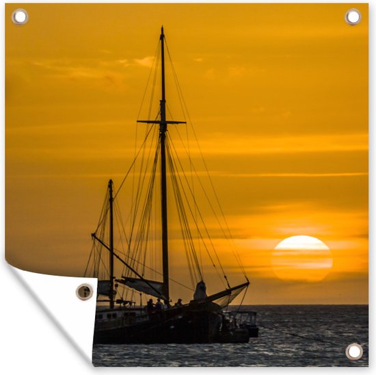Tuindoek Grote zeilboot vaart in de zee tijdens zonsondergang in Aruba ...