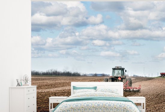 Behang - Fotobehang De boer met een ploeg achter zijn tractor - Breedte ...