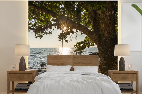 Behang - Fotobehang Een tropische boom met schommel bij het strand van Ko Chang -... | bol