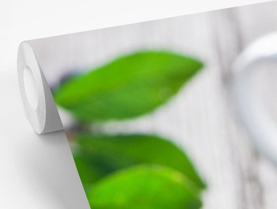 Behang - Fotobehang Close up van pruimen in een keramische schaal op ...