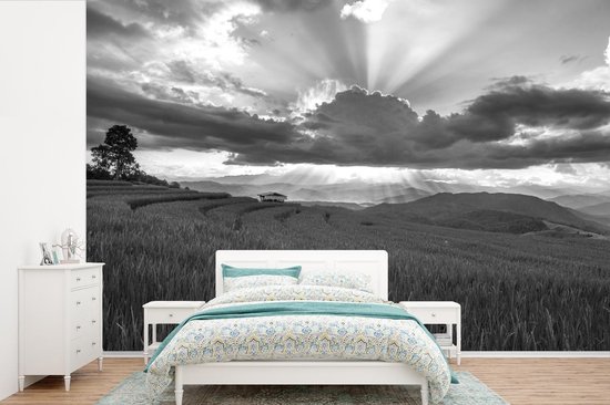 Behang - Fotobehang Zonnestralen bij een zonsondergang over het ...