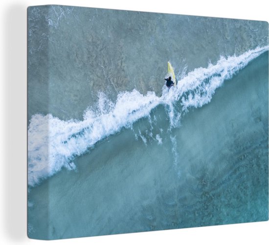 Canvas schilderij 160x120 cm - Wanddecoratie Luchtfoto van een surfer in de blauwe... | bol