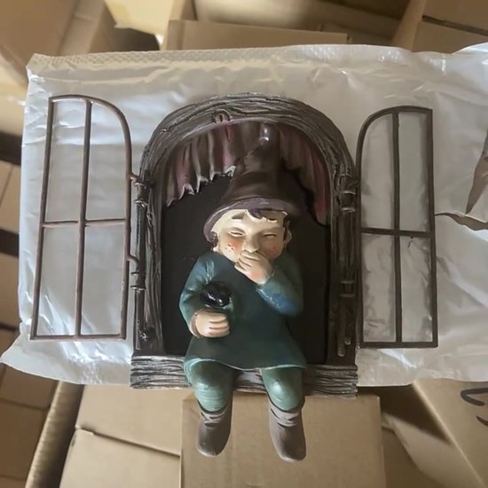 Charmante kabouter zit op het raam-ophangbaar standbeeld van duurzame ...