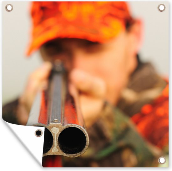 Tuin poster Een close-up van een jager die zijn geweer op de camera ...