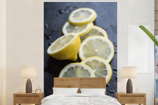 Behang - Fotobehang Citroen schijfjes versieren de donkere tafel ...