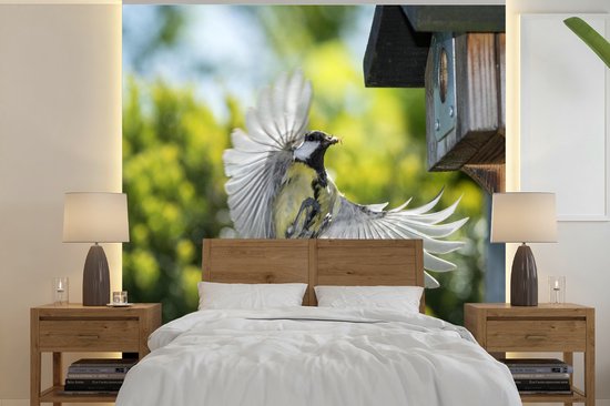 Behang - Fotobehang Een koolmees vliegt een vogelhuisje in - Breedte ...