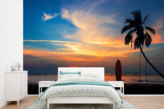 Behang - Fotobehang Silhouet van een surfplank en een palmboom op het ...